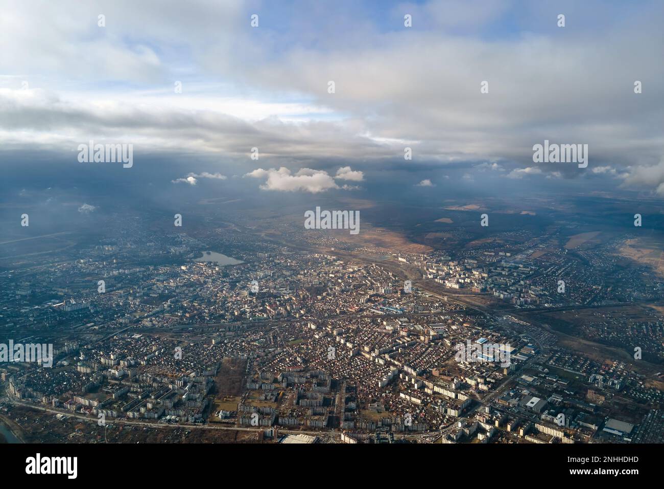 Aerial view from high altitude of distant city covered with puffy ...