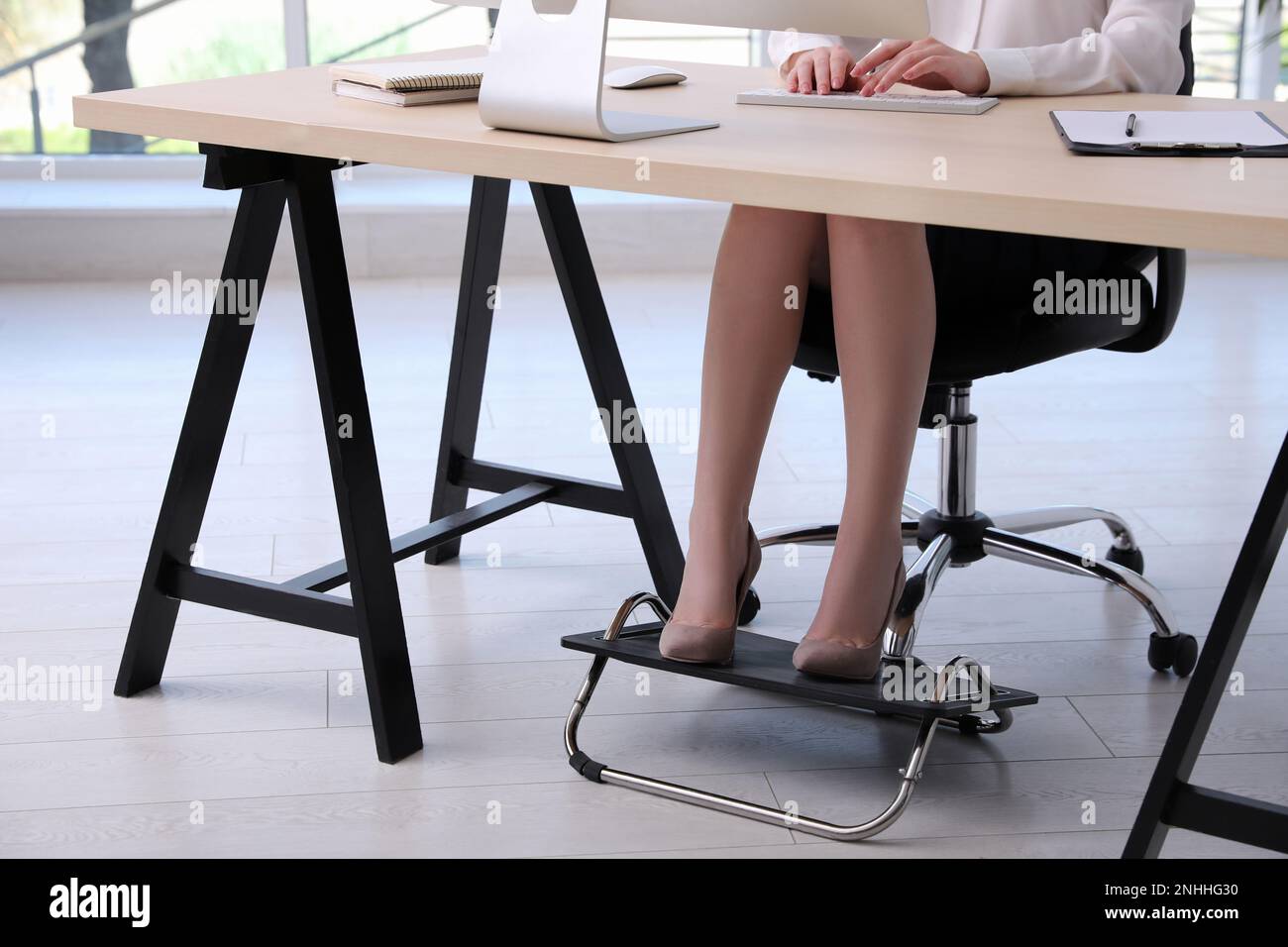 Woman using footrest while working on computer in office, closeup Stock ...