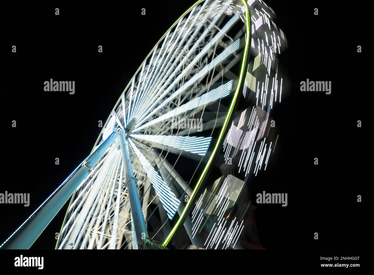 Beautiful glowing Ferris wheel against dark sky, motion blur effect ...