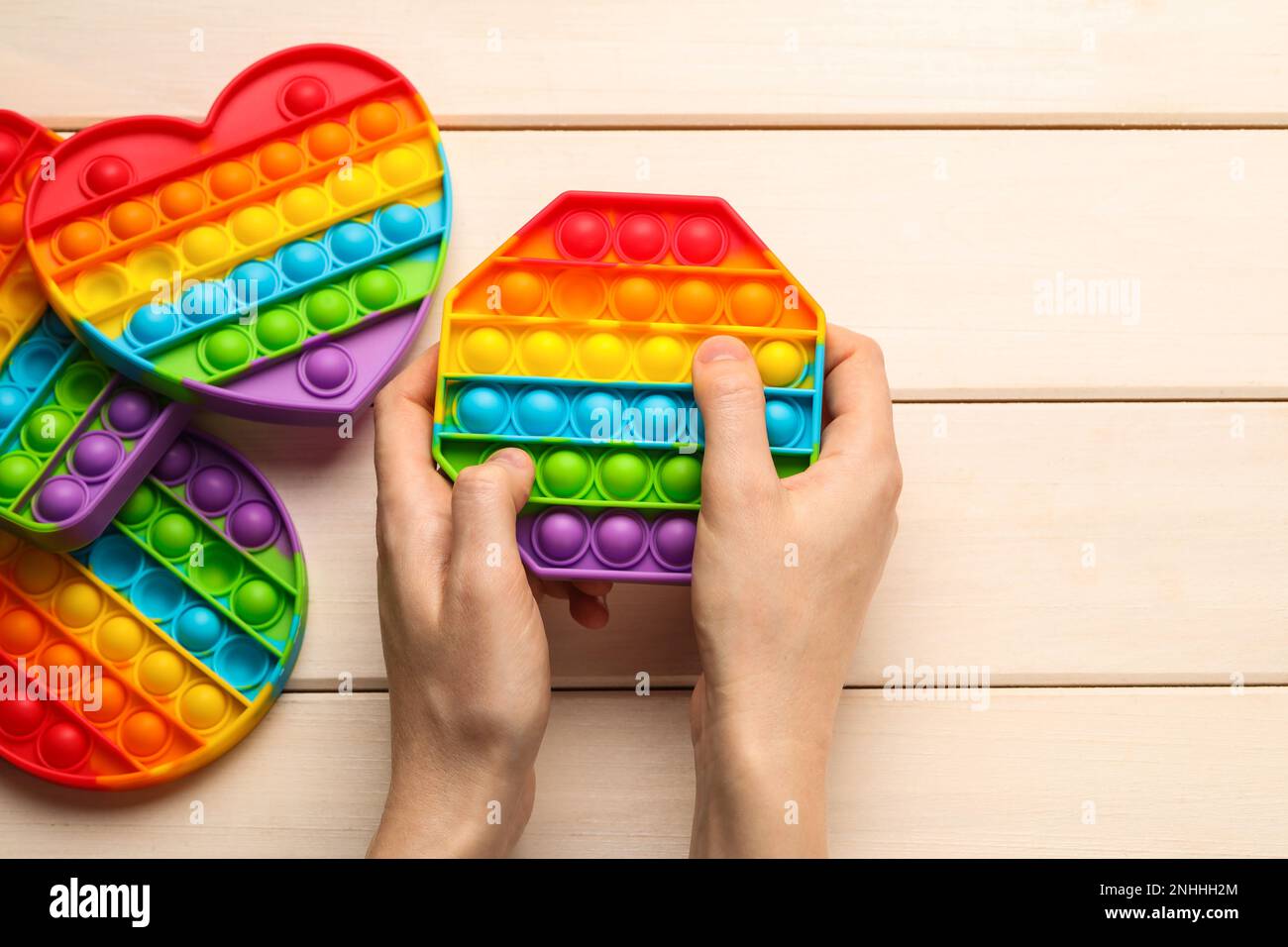 Woman using pop it fidget toy at white wooden table, top view Stock ...