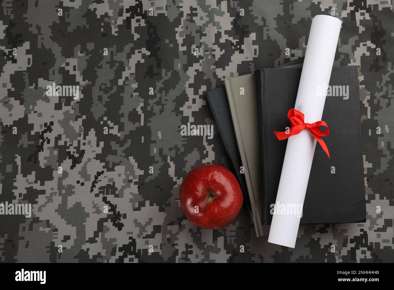 Books, apple and diploma on camouflage background, flat lay with space ...