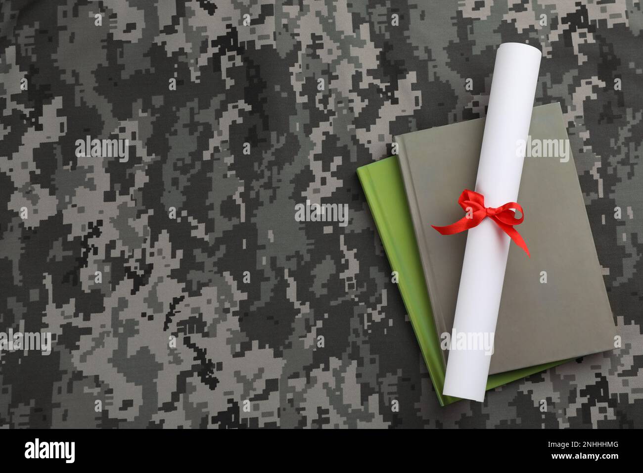 Books and diploma on camouflage background, top view with space for ...