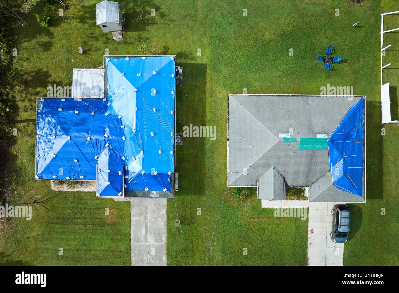 Aerial view of damaged in hurricane Ian house roofs covered with blue ...