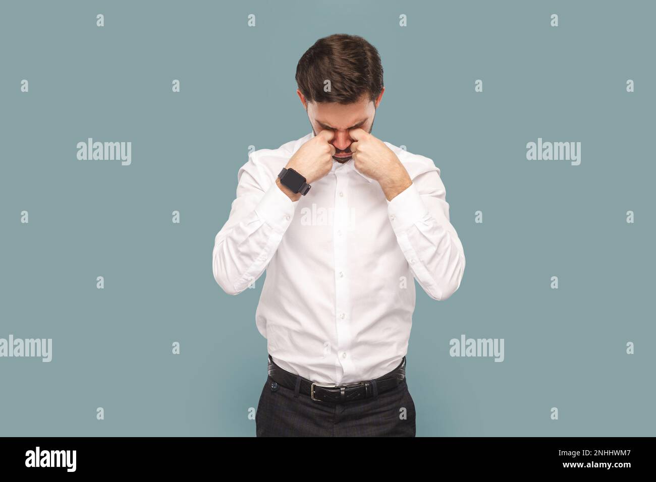 Portrait of sad depressed crying man with mustache standing and rubbing ...