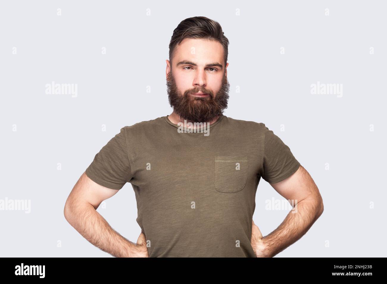Portrait of bearded man wearing dark green T-shirt looking cross-eyed ...
