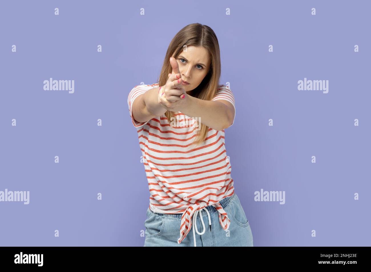 Portrait of serious brave blond woman wearing striped T-shirt holding ...