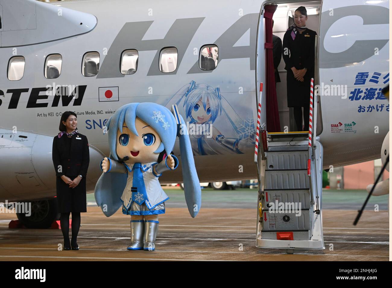 Passengers pose with Snow Miku, a supporting character to promote ...
