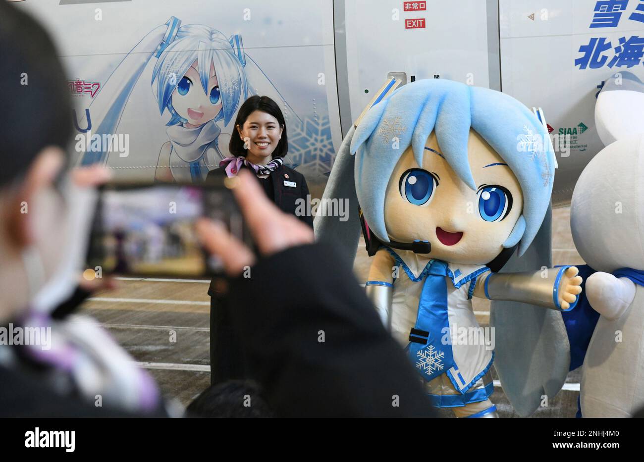 Passengers pose with Snow Miku, a supporting character to promote ...