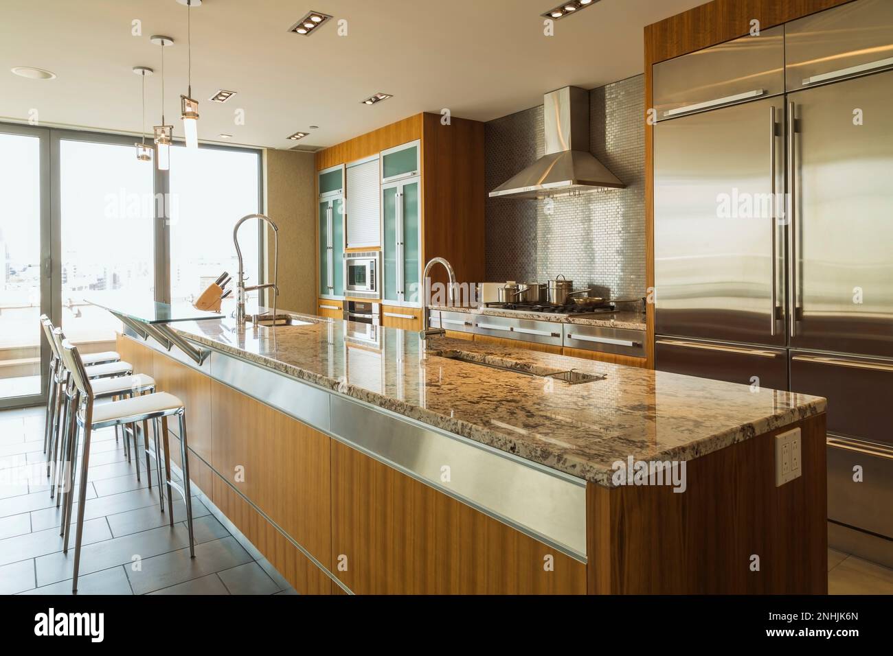 Island with grey nuanced granite countertop and white leather high back ...