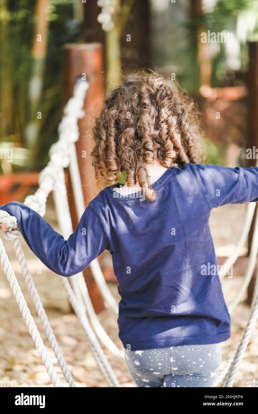 Preschool child playing on rope swing. Beautiful tropical kindergarten ...