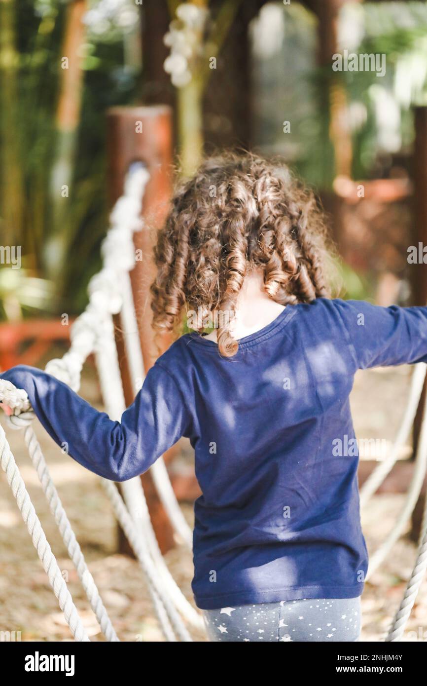 Preschool child playing on rope swing. Beautiful tropical kindergarten ...