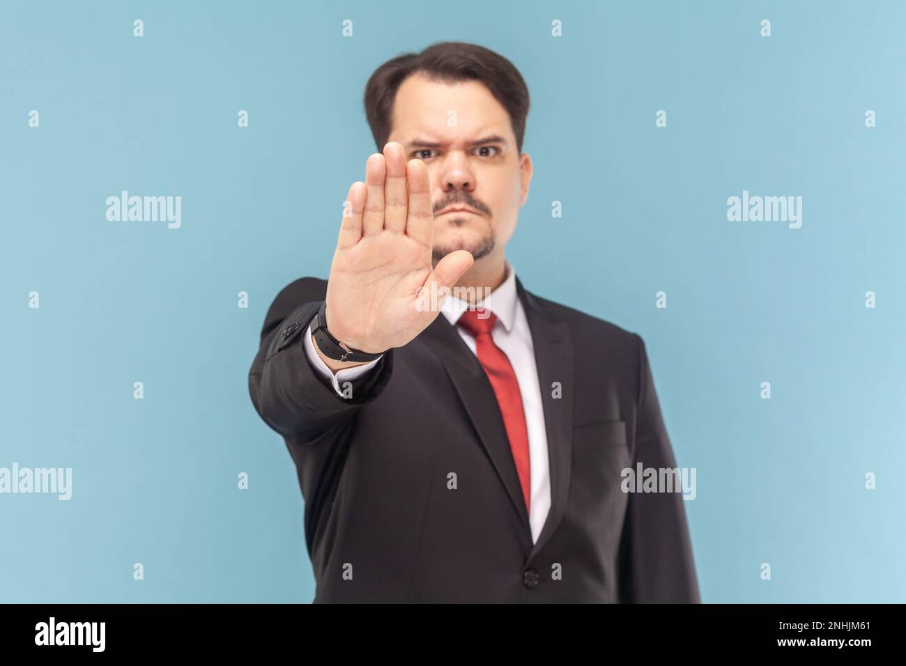 Portrait of strict bossy man with mustache showing block gesture ...