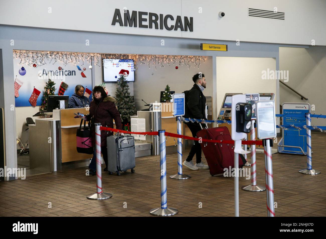 Passengers check into their flights at the American Airlines counter at ...