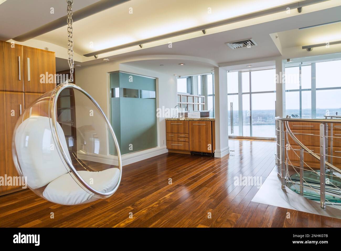 Clear plastic half-sphere chair suspended from the ceiling in home ...