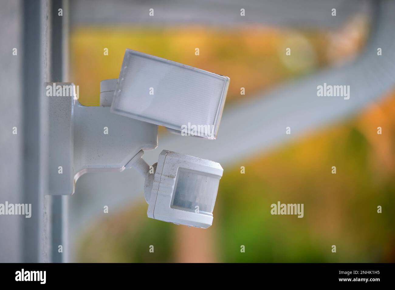 Motion sensor with light detector mounted on exterior wall of private ...