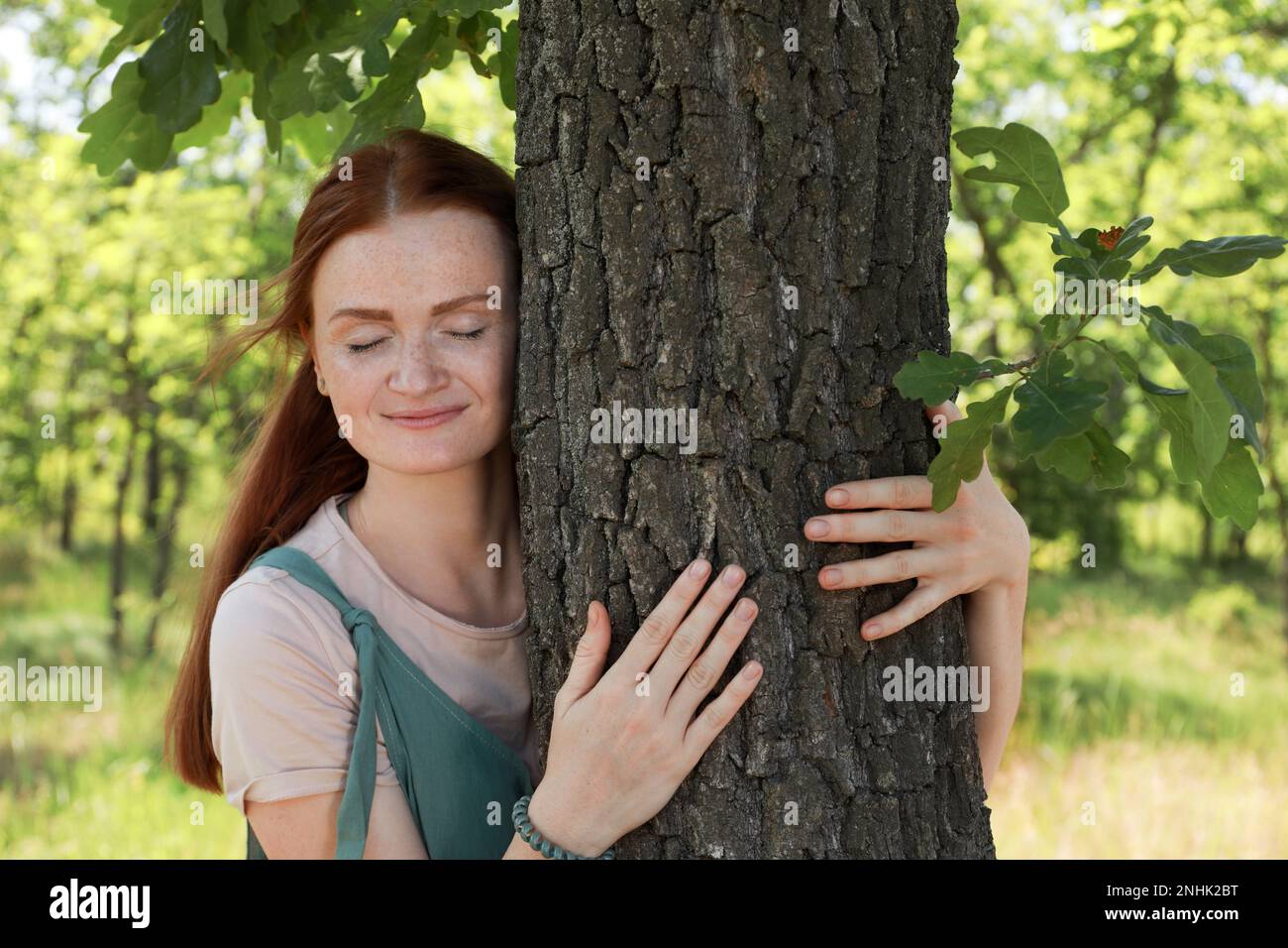 Beautiful woman hugging tree trunk in forest Stock Photo - Alamy