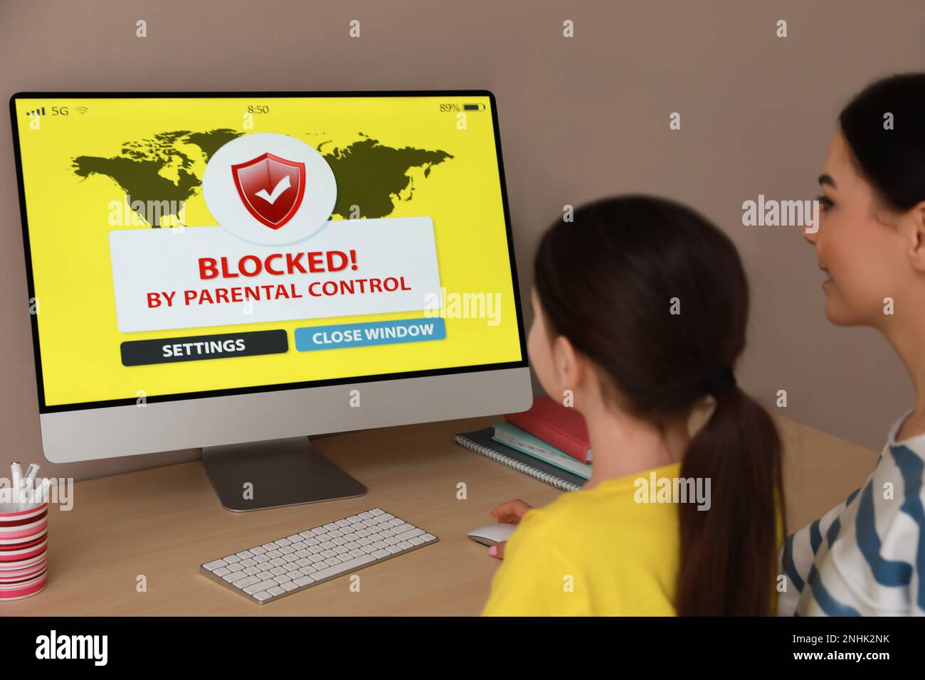 Mom installing parental control on computer at table indoors. Child ...