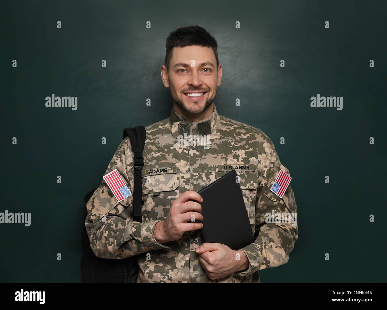 Cadet with backpack and tablet near chalkboard. Military education ...