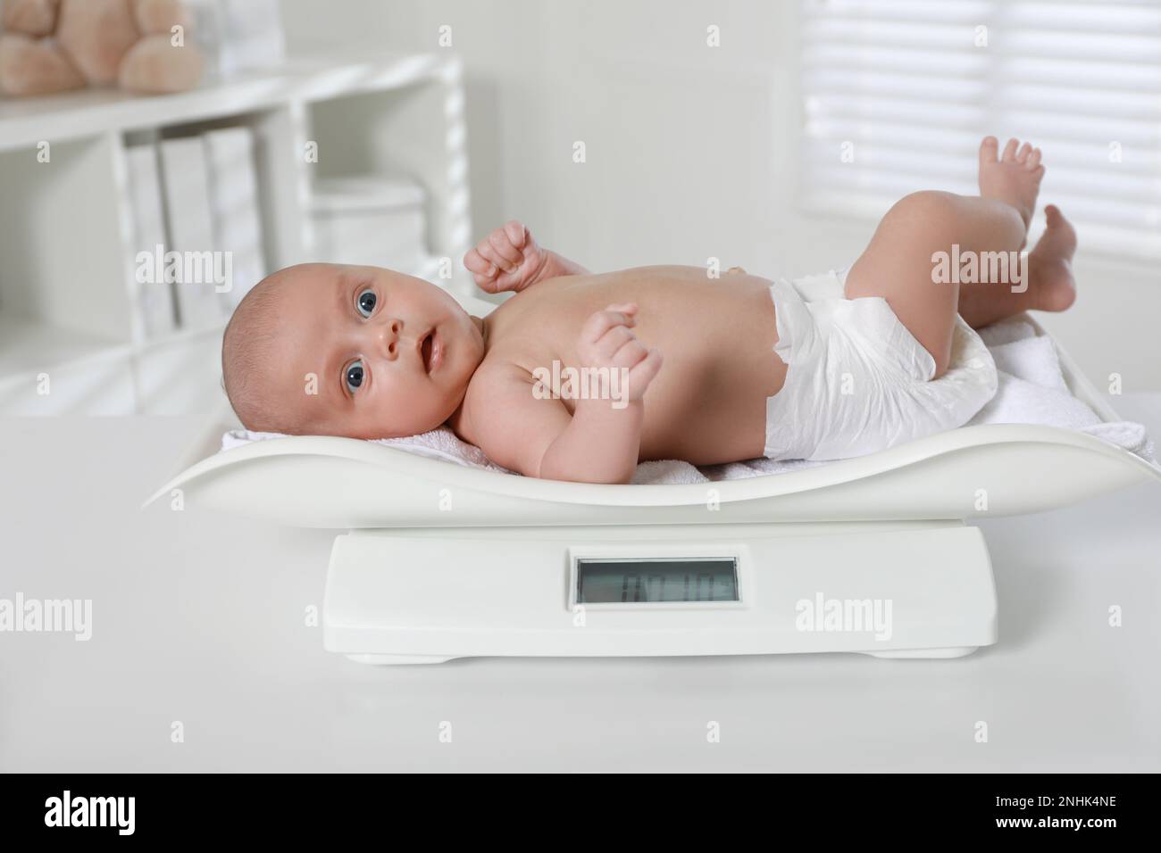 Cute little baby lying on scales in clinic Stock Photo - Alamy