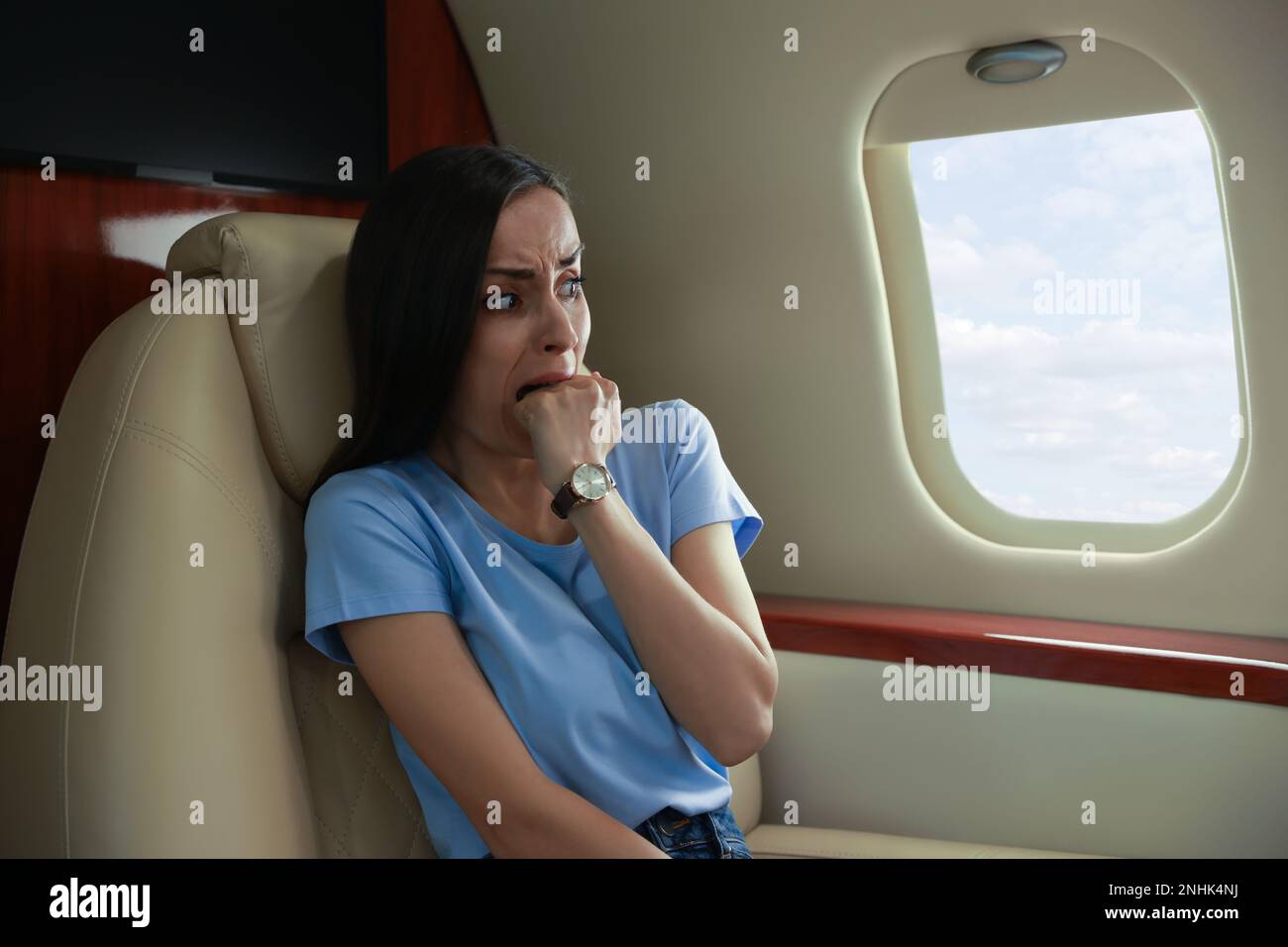 Nervous young woman suffering from aviophobia in airplane Stock Photo ...