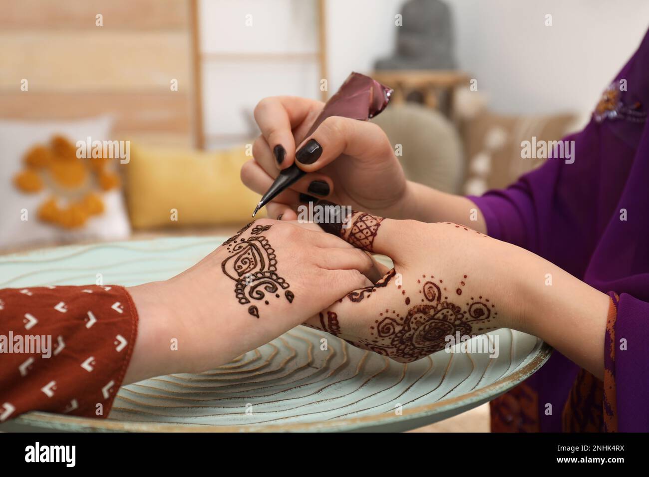 Professional mehndi master making henna tattoo indoors, closeup Stock ...