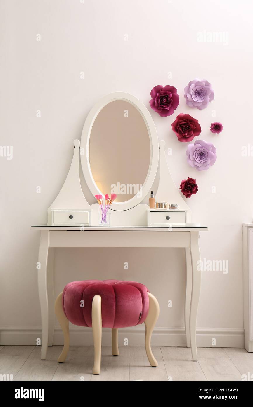 Stylish room interior with floral decor, dressing table and pouf Stock ...