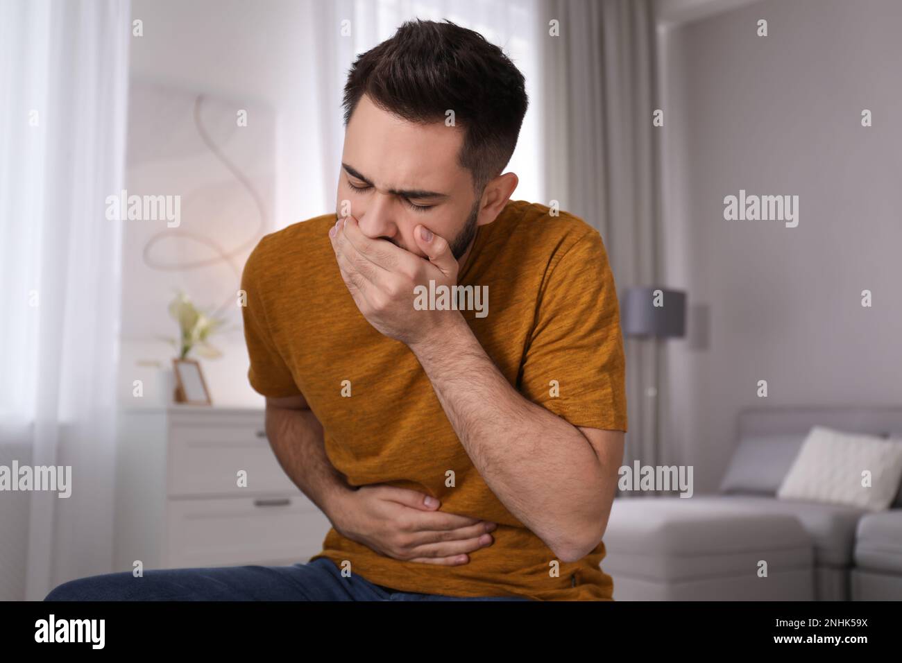 Young man suffering from nausea at home. Food poisoning Stock Photo - Alamy