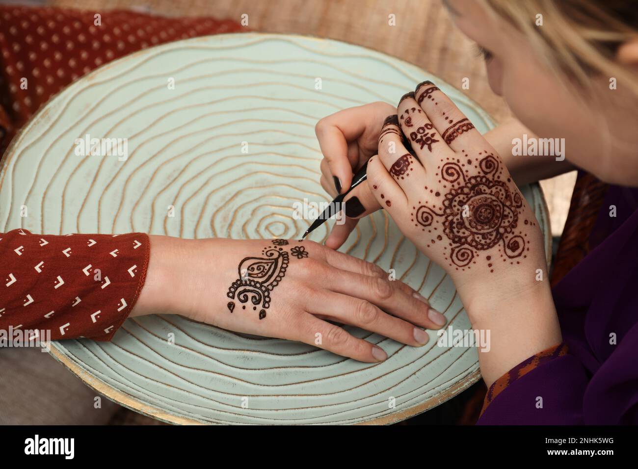 Professional mehndi master making henna tattoo at table, closeup Stock ...