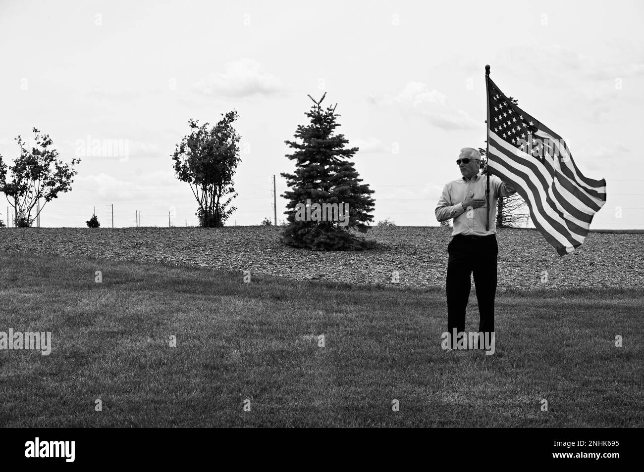 An observer stands on the side of the road during the funeral ...