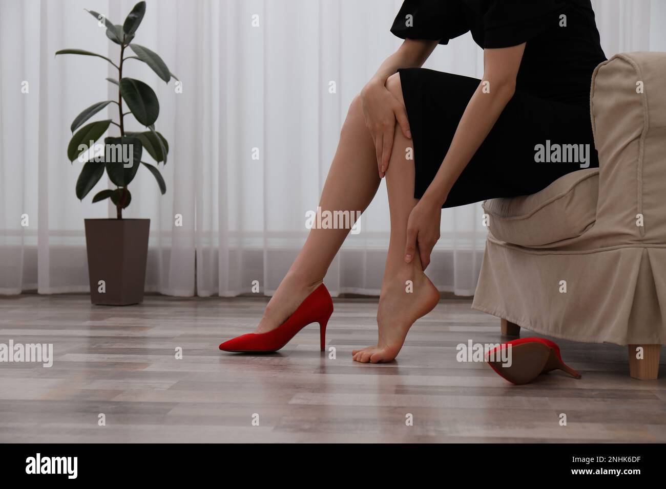 Young woman taking off shoes at home, closeup. Tired feet after wearing ...