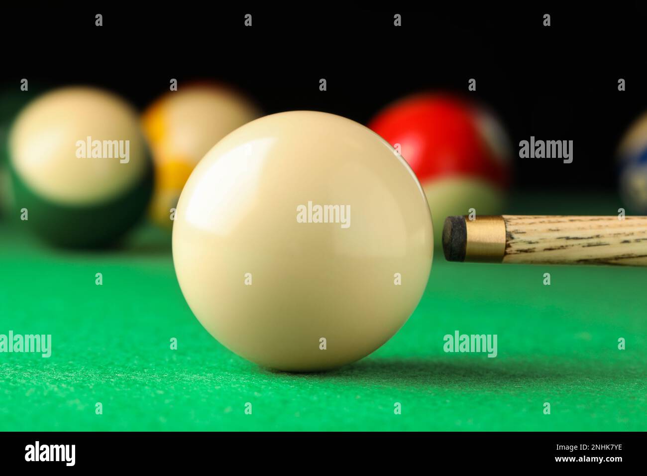 Classic plain billiard ball and cue on green table, closeup Stock Photo ...