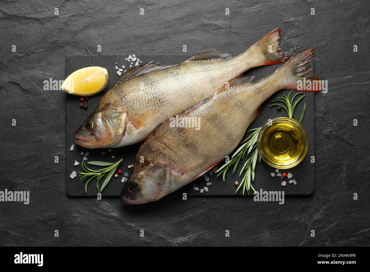 Fresh raw perches and ingredients on black slate table, top view. River ...
