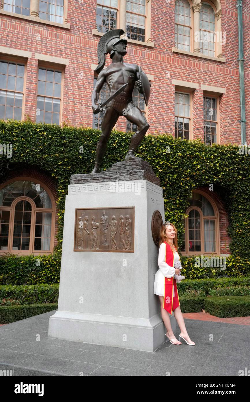 A USC female 2023 graduate poses with Tommy Trojan mascot statue ...