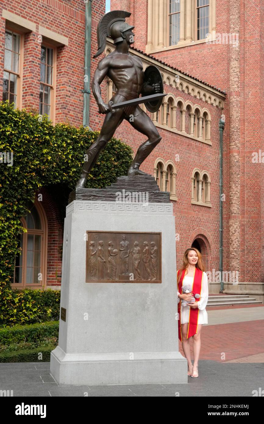 A USC female 2023 graduate poses with Tommy Trojan mascot statue ...