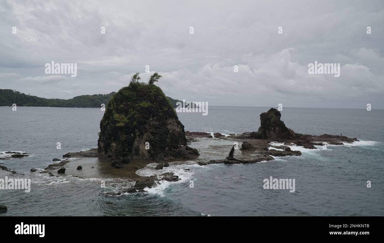 The rock that towers on the beach and is buffeted by the waves Stock ...