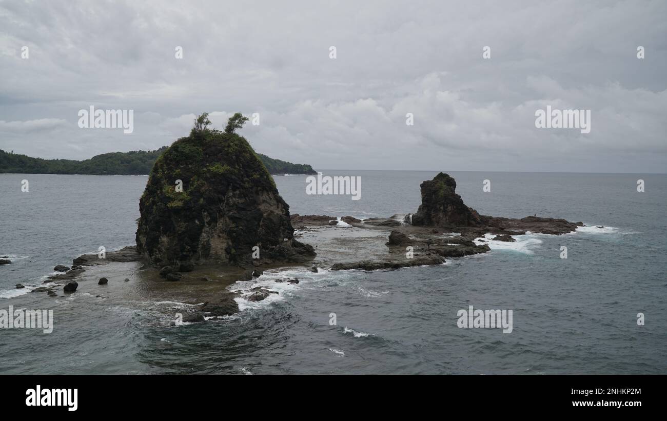 The rock that towers on the beach and is buffeted by the waves Stock ...
