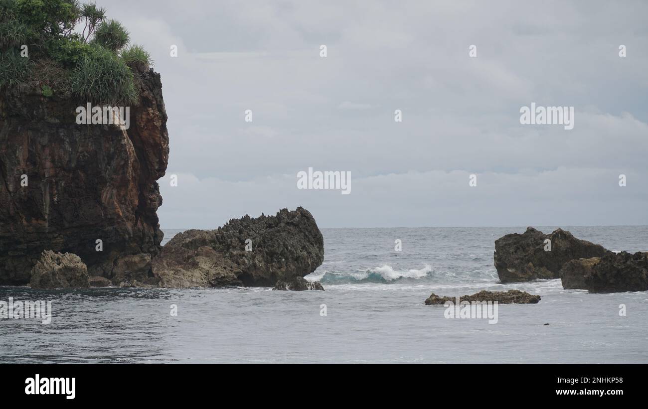 The rock that towers on the beach and is buffeted by the waves Stock ...