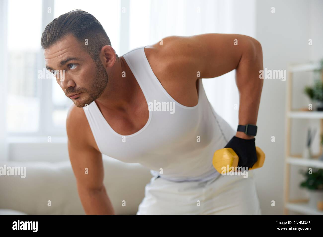 Man sports home training on the floor on a mat with dumbbells ...