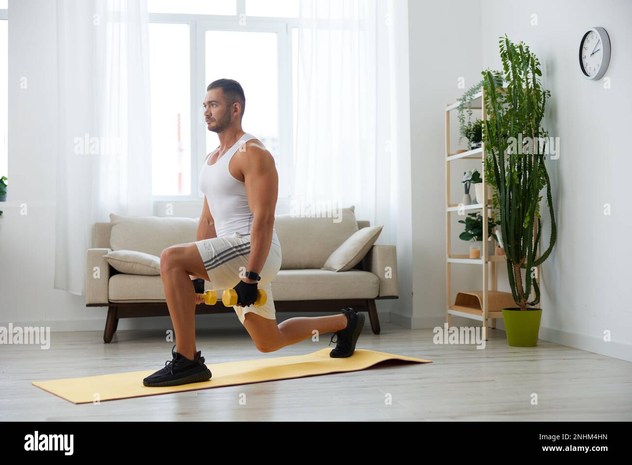Man sports home training on the floor on a mat with dumbbells ...