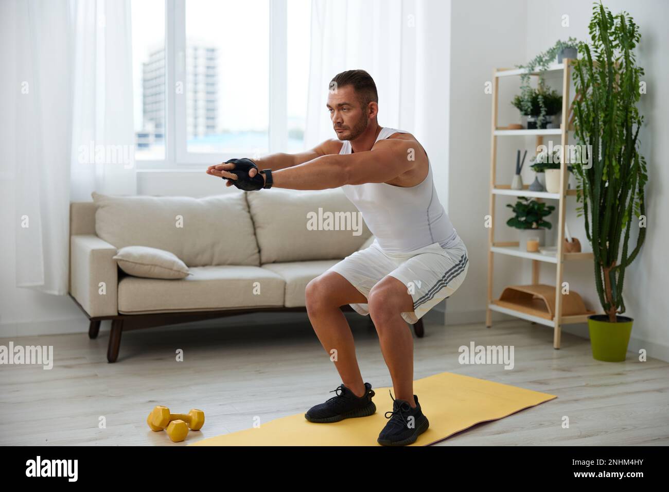 Man sports home training on the floor on a mat with dumbbells ...