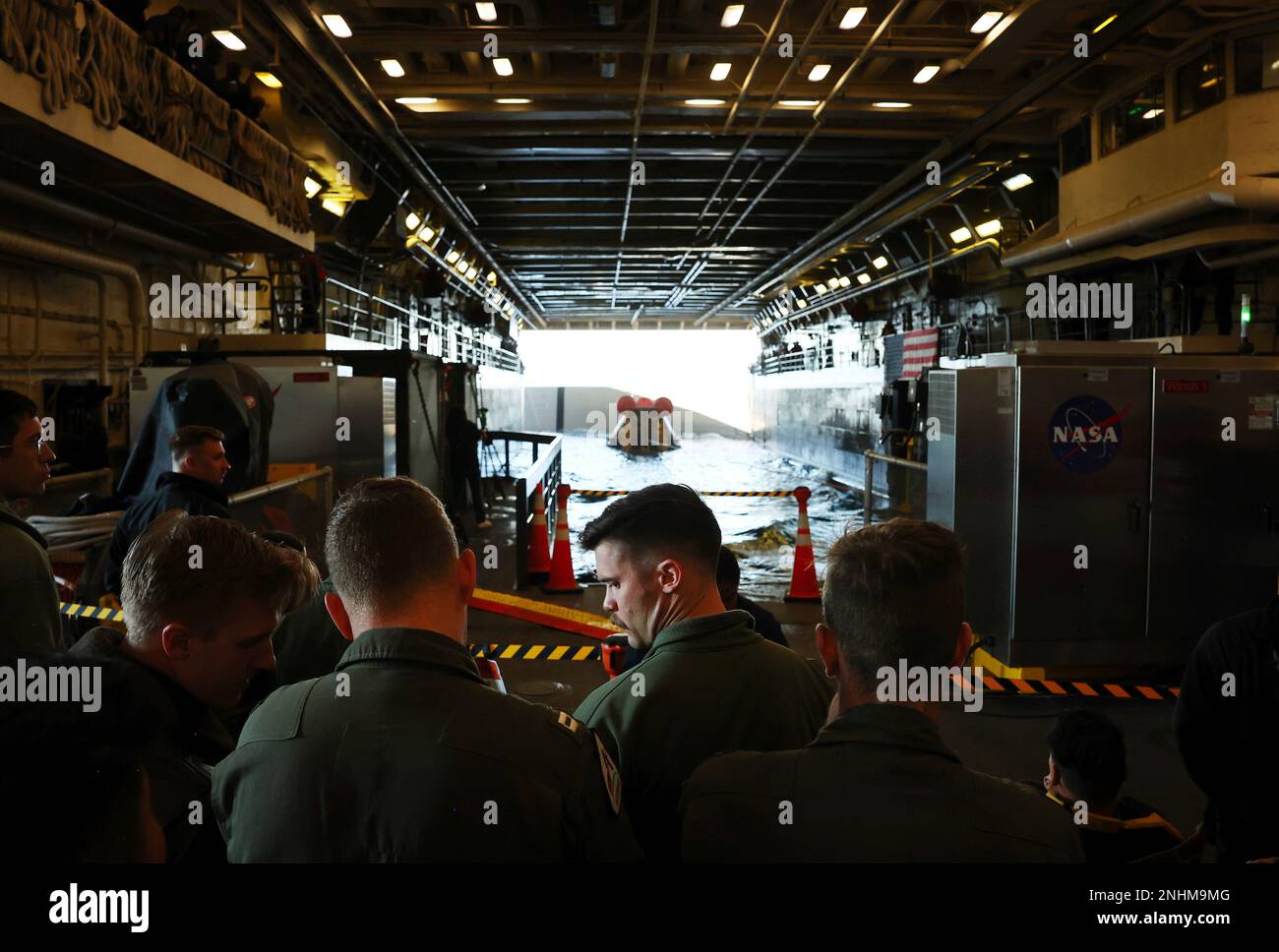 U.S. Navy pilots gather after NASA's Orion Capsule was brought into the ...