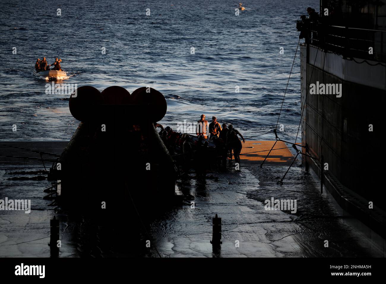 A U.S. Navy dive team returns to the well deck after securing NASA's ...