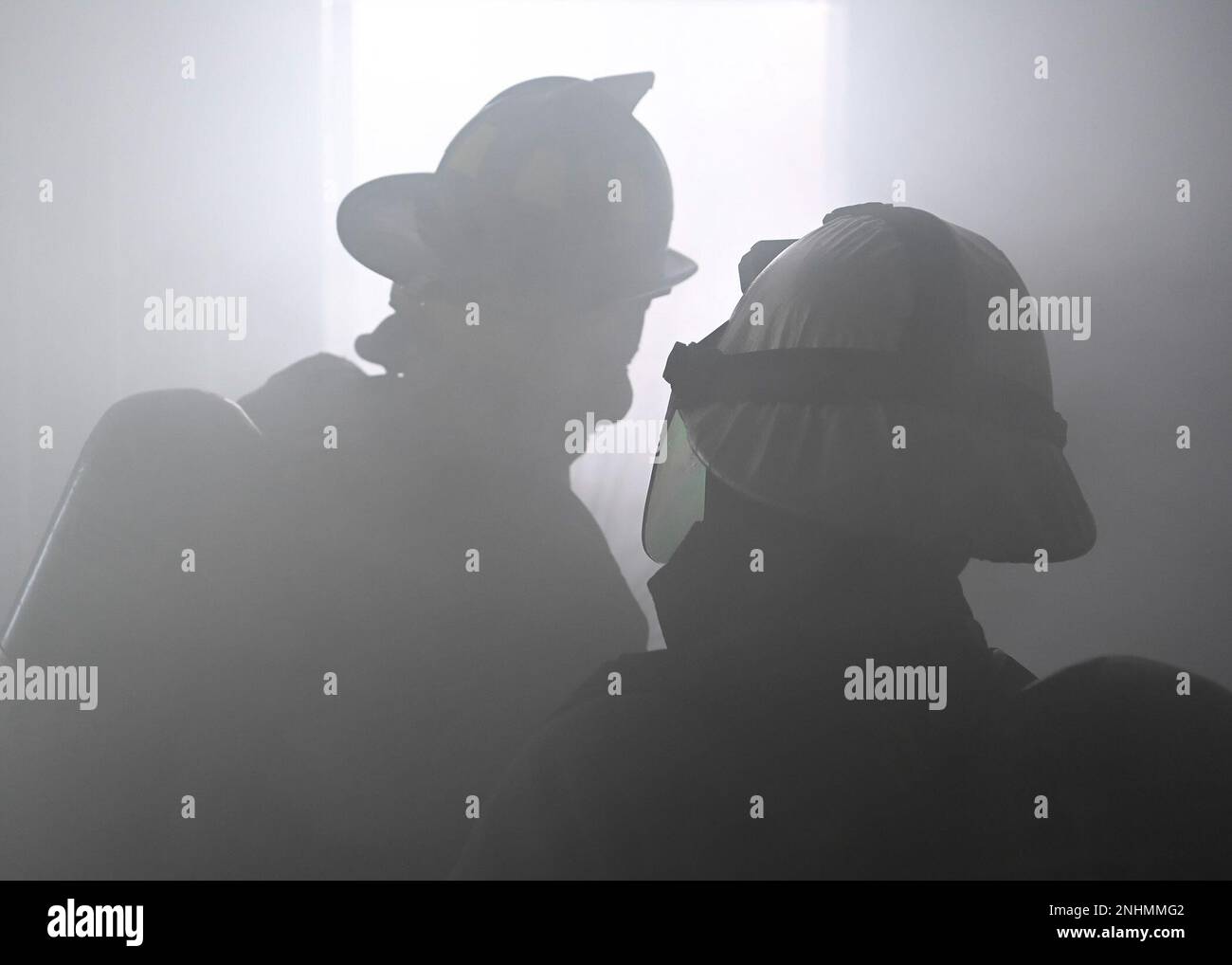 Two cadets clear smoke from a simulated structure fire during the 2022 ...