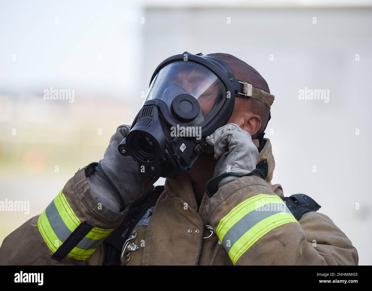 A cadet puts on his firefighting gear before entering the simulated ...