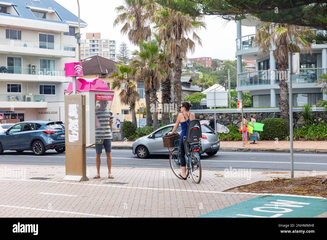 Lady woman riding her bicycle bike on the pavement in Manly Beach ...