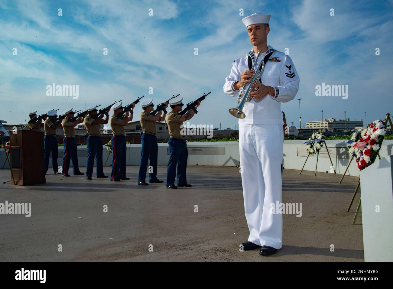 U.S. Marines perform a rifle salute before a Navy bugler plays taps ...