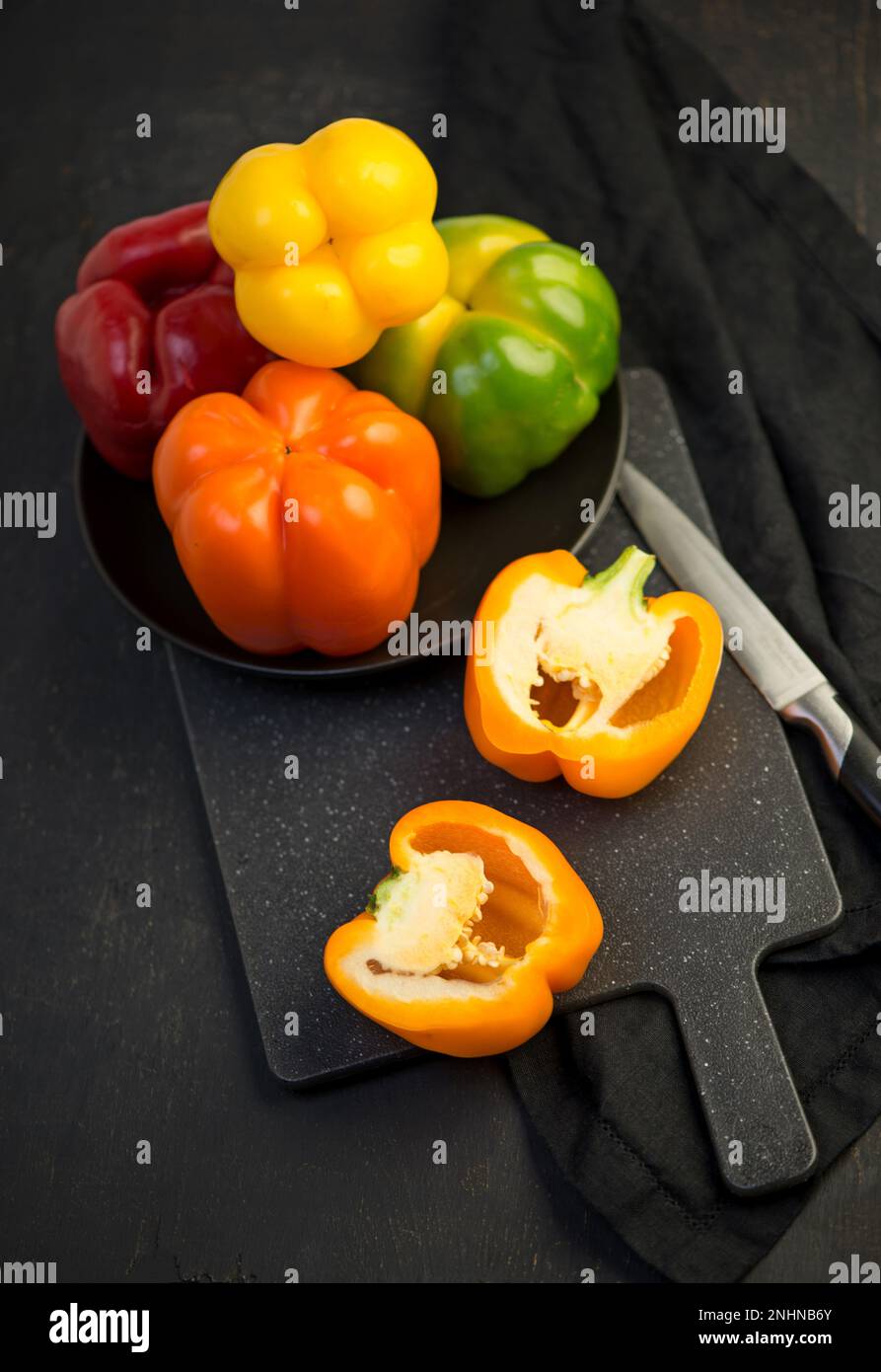 colored peppers on black background Stock Photo - Alamy