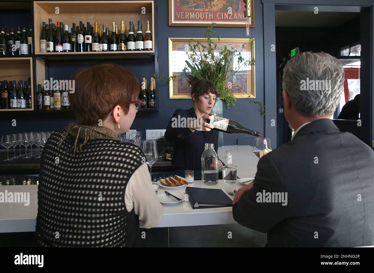 Bartender Stephanie Roman pours a glass of wine for Lisa Ennis (left ...