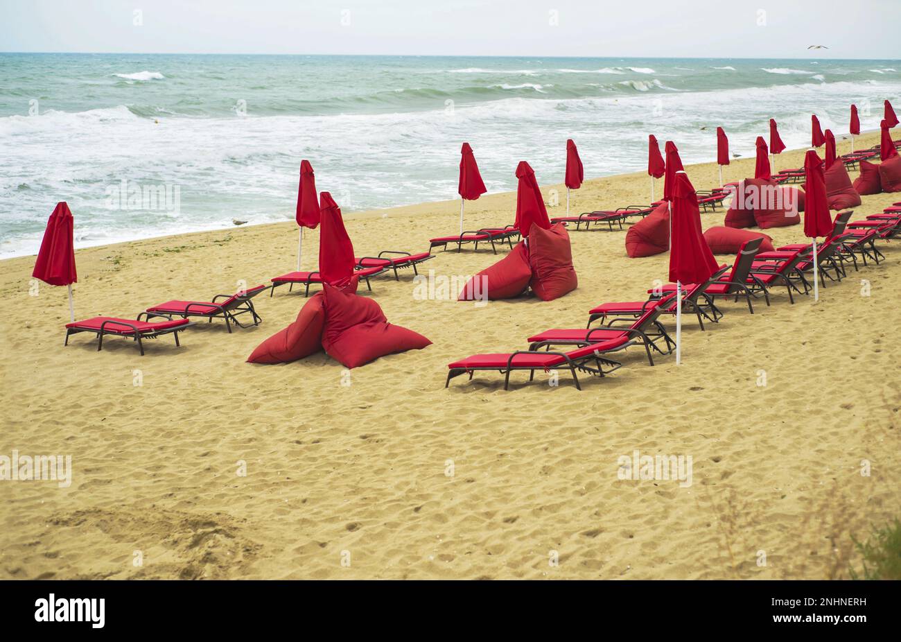 Bad weather. Deserted beach. Empty sun loungers next to the stormy sea ...