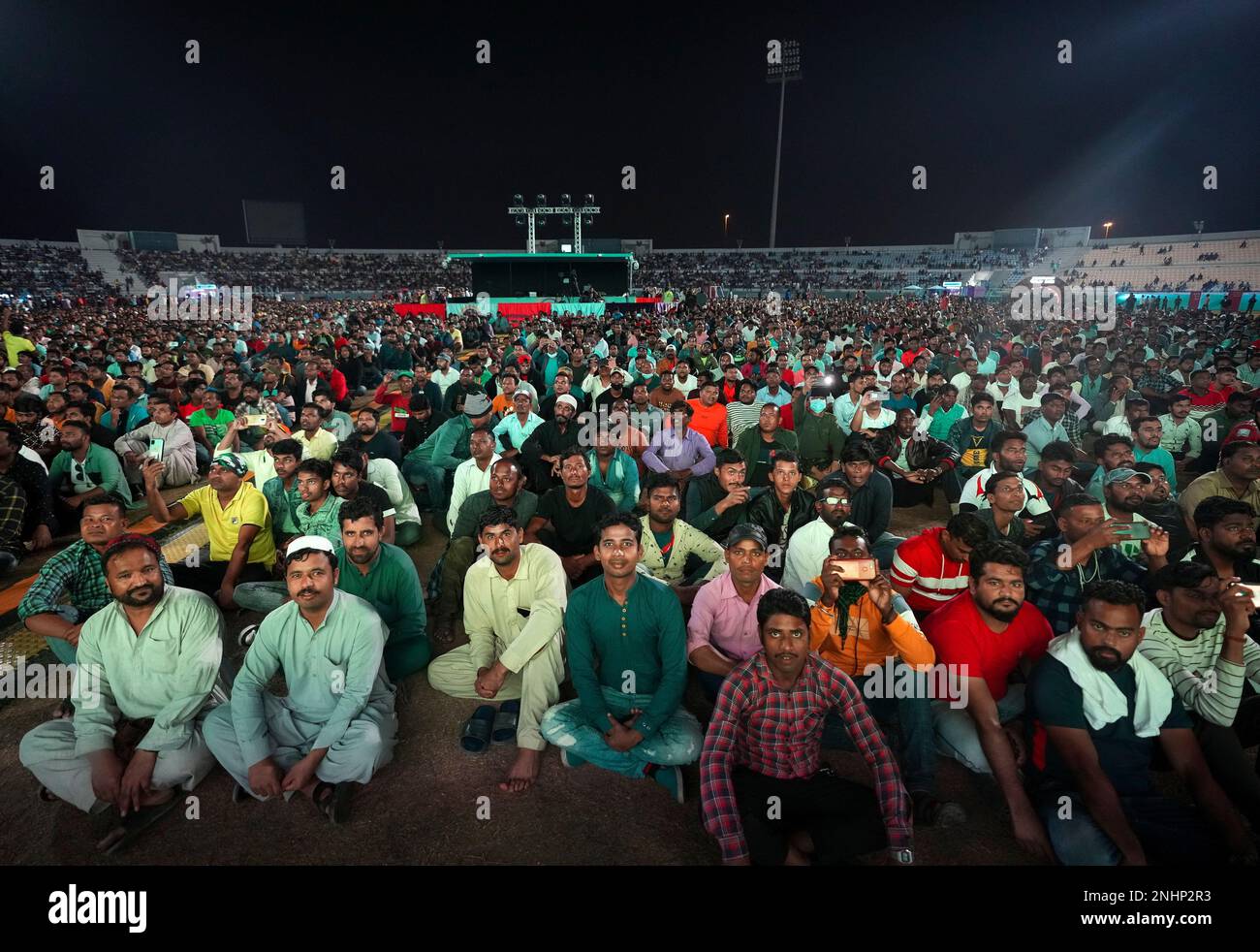 Migrant workers watch soccer on a big projection screen during the World Cup at the Asian Town ...